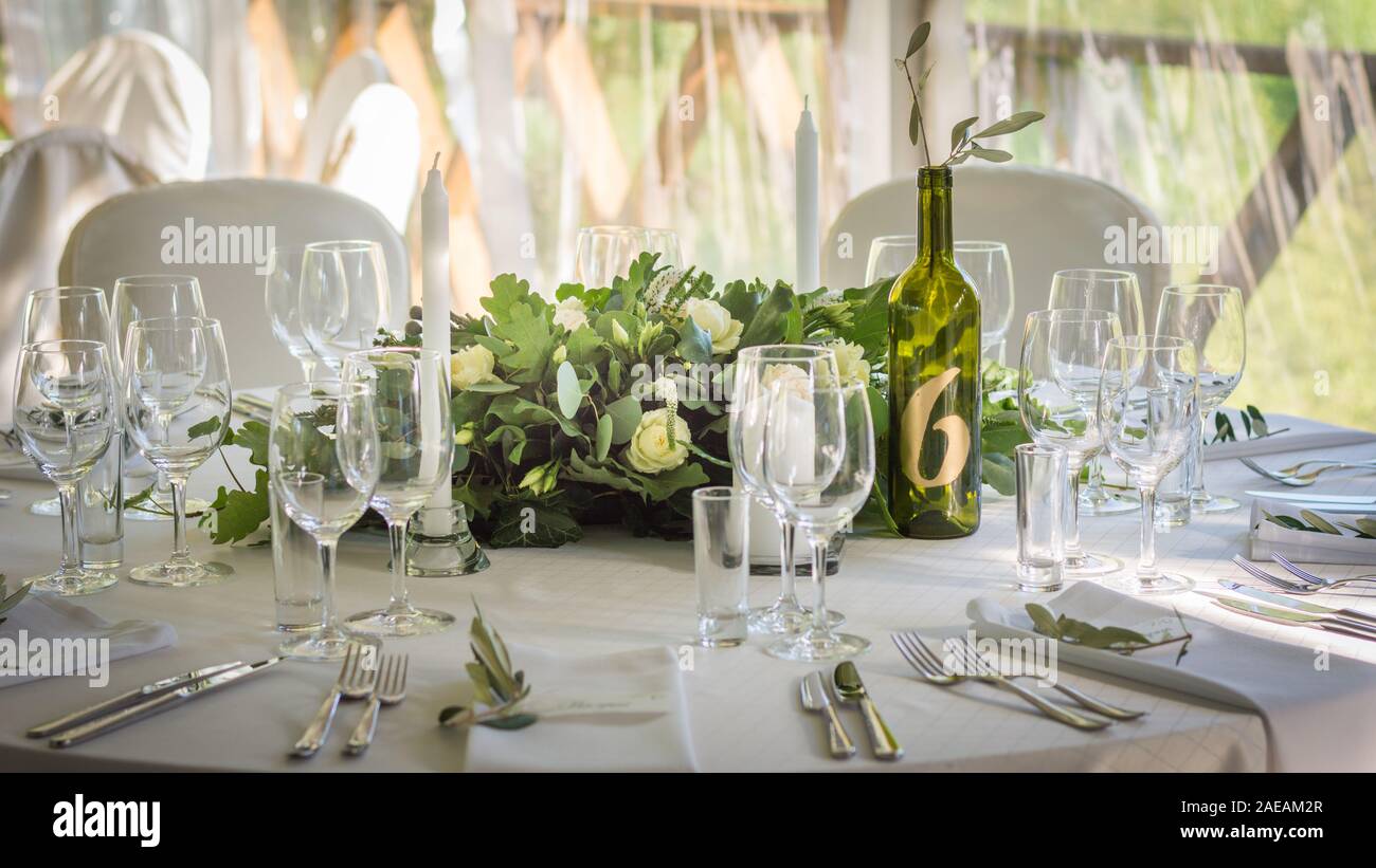Decorated wedding tables with numbers on bottles and beautiful rose ...