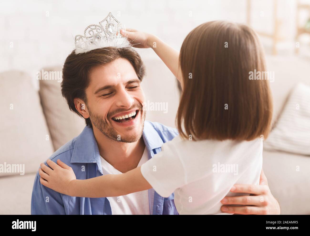 Little girl putting crown on her dad head Stock Photo - Alamy