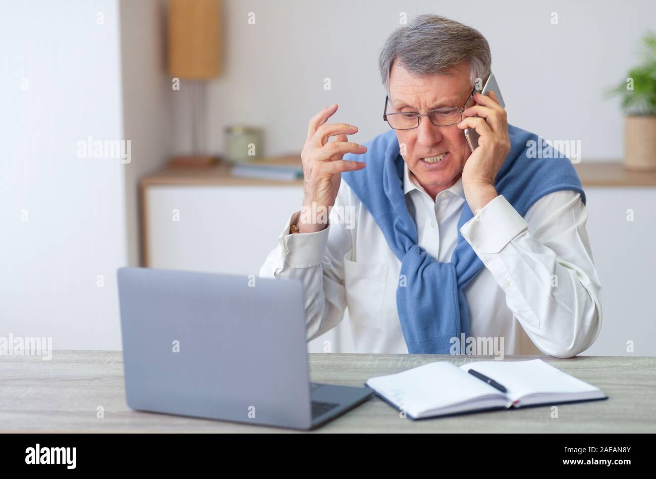Discontented Elderly Man Calling To Customer Support Sitting At ...