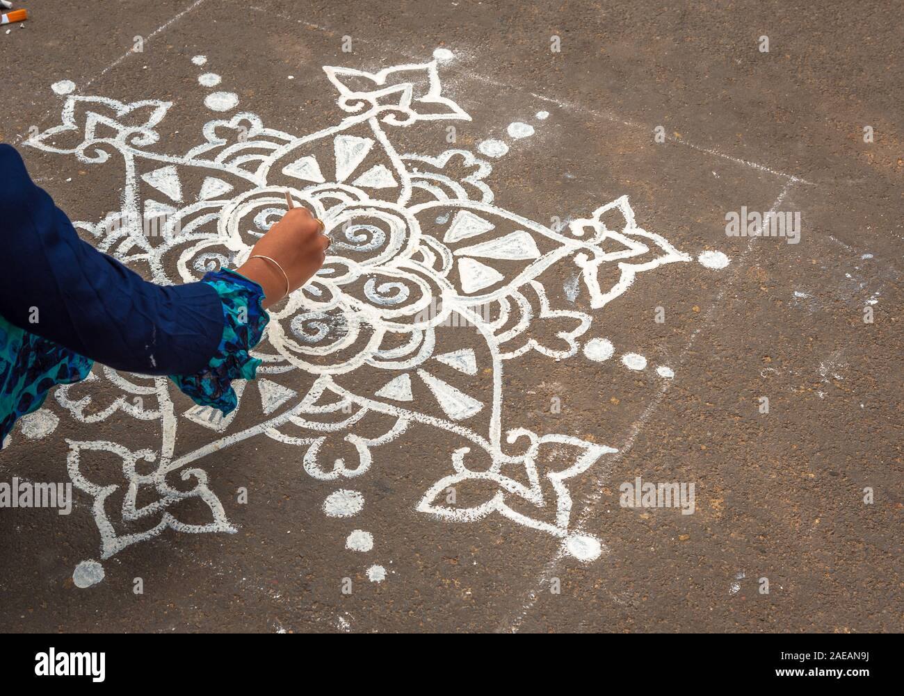 Hand of an Artist with brush drawing Alpona on the Street Stock Photo ...