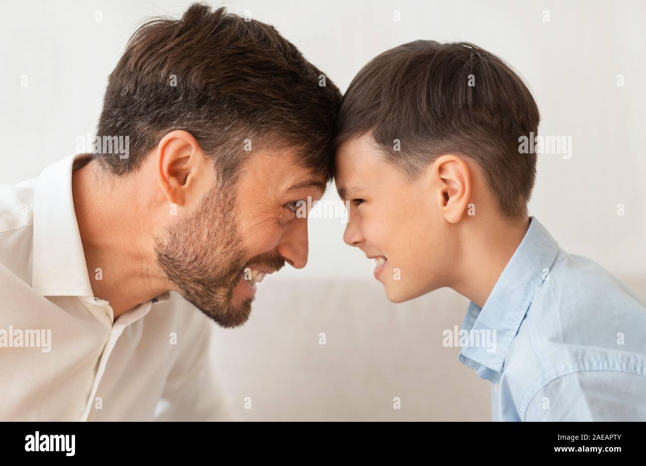 Happy Father And Son Bowing Heads Touching Foreheads, White Background ...