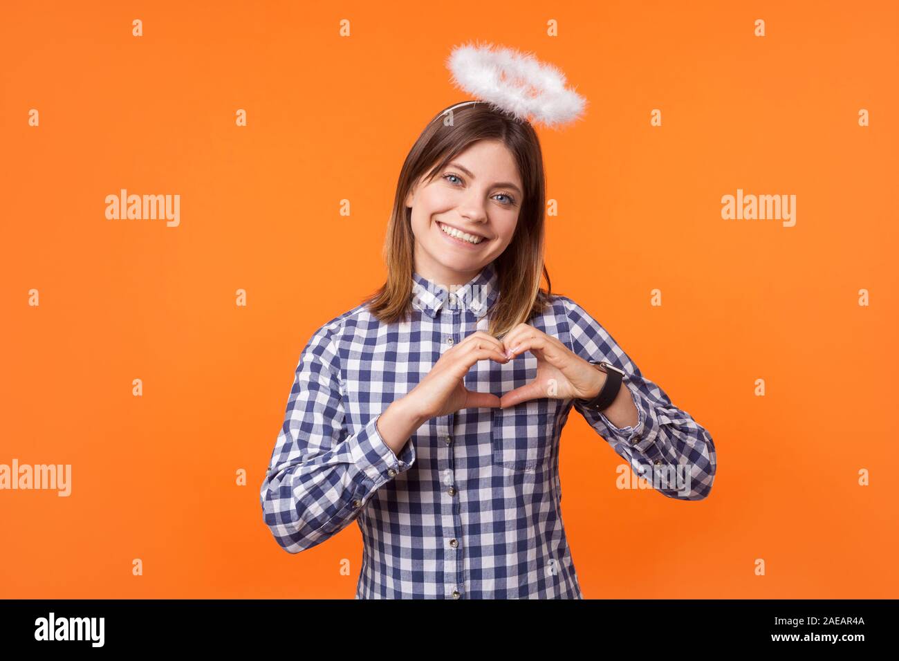 Portrait of angelic young woman with charming smile wearing checkered ...