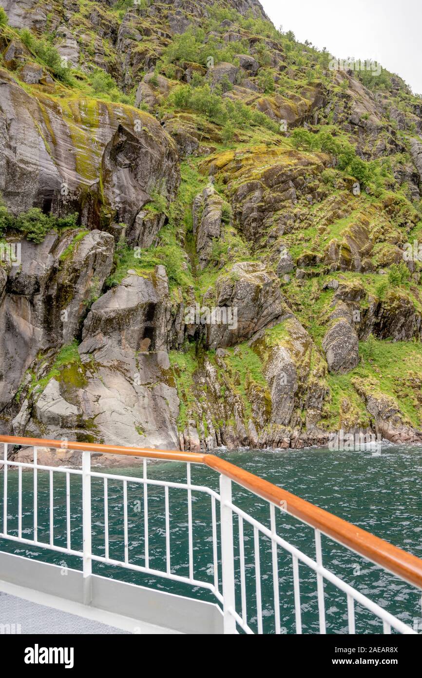 steep rocky green side of narrow fjord just out of liner deck railings ...