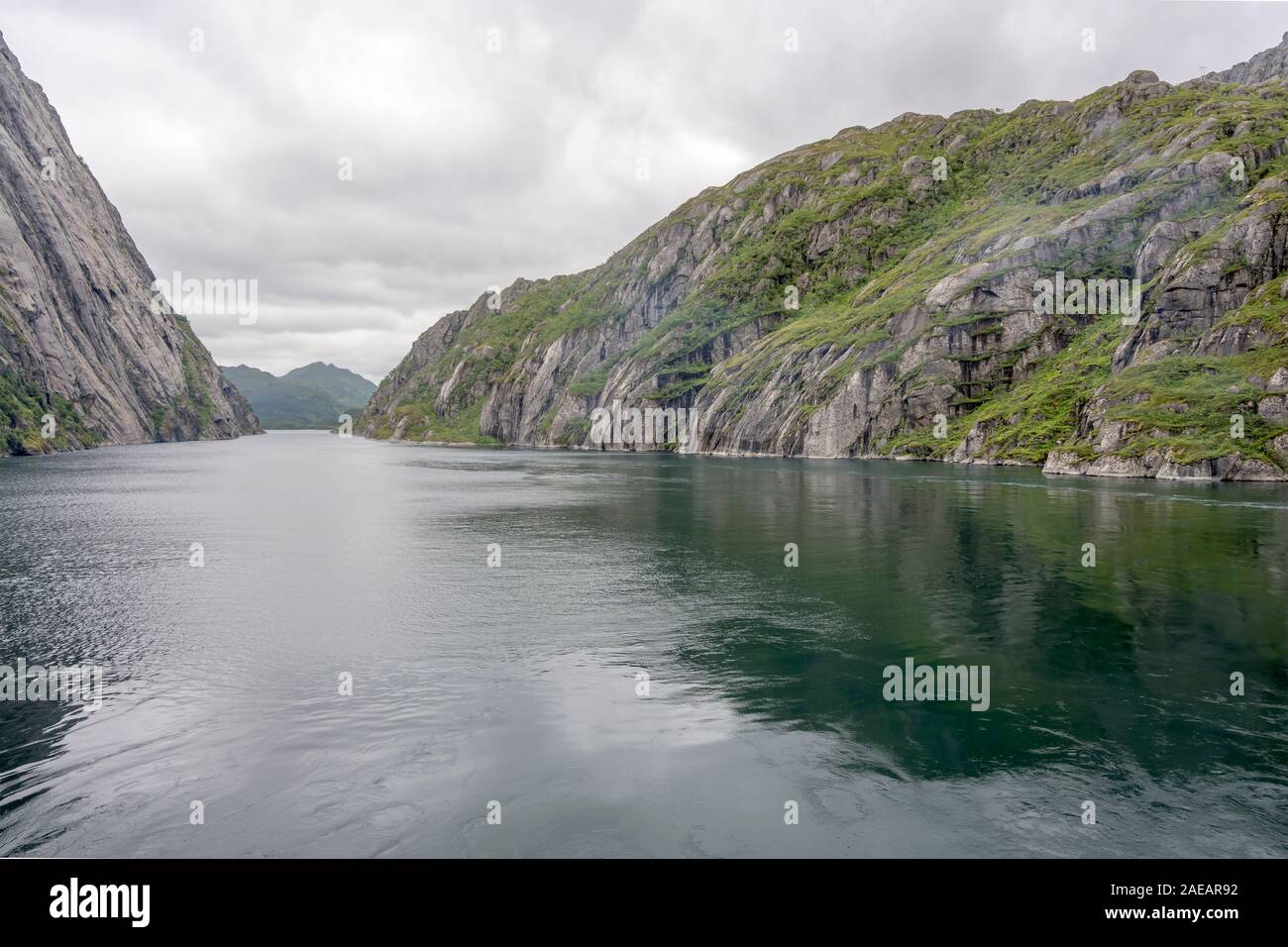 landscape with steep sides of narrow fjord, shot under bright cloudy ...