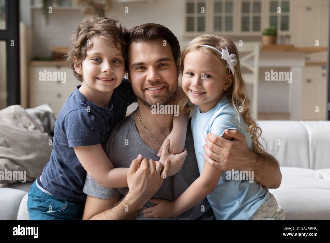 Young father and little kids embracing looking at camera Stock Photo ...