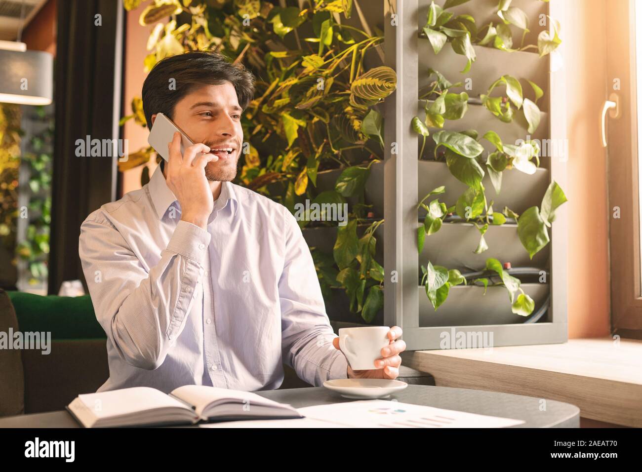 Young man making an appointment via cellphone Stock Photo - Alamy