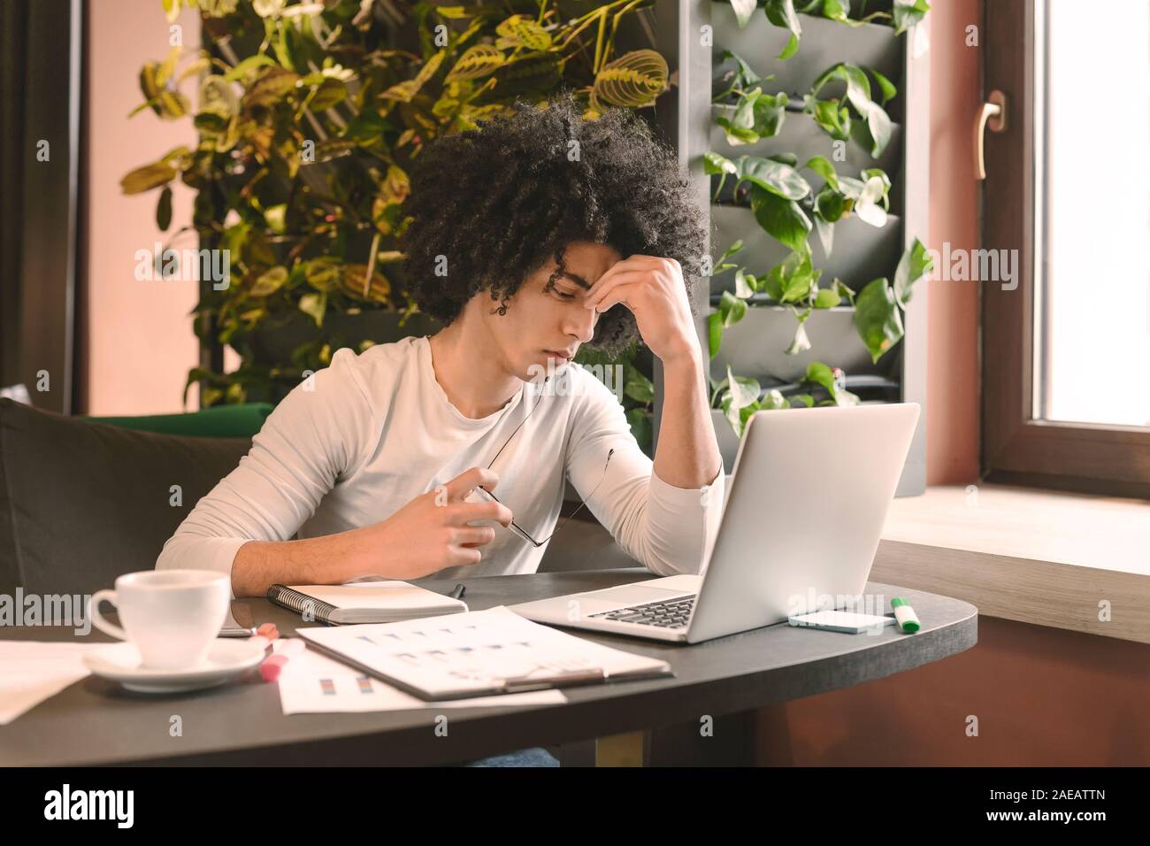 Stressed desperate man sitting in cafe with laptop Stock Photo - Alamy