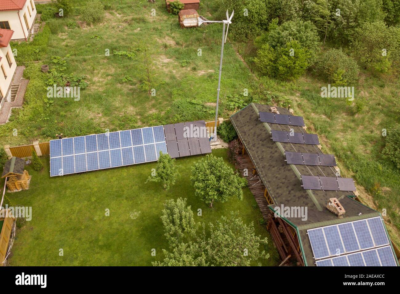 Aerial view of a barn with solar panels on roof and wind generator ...