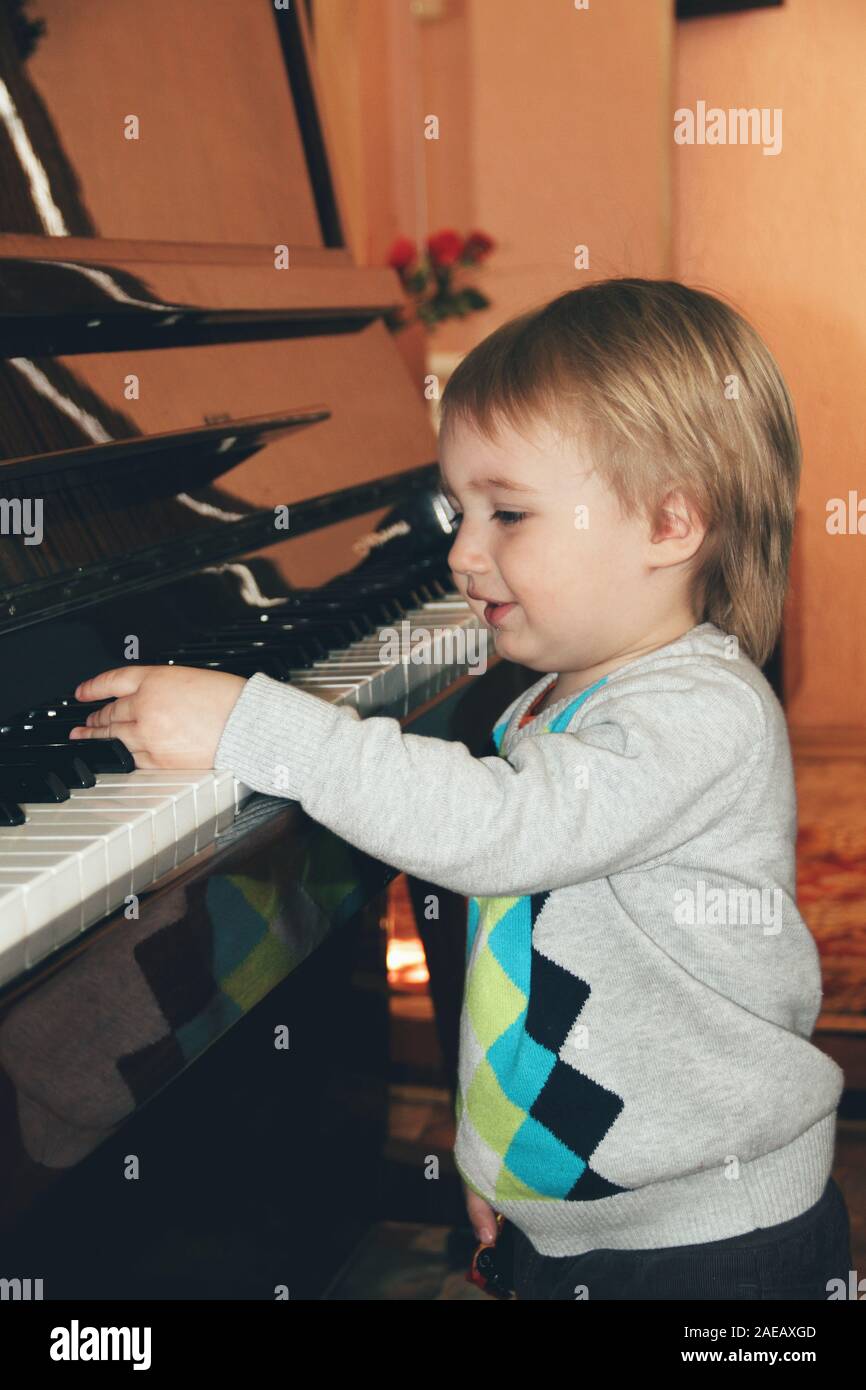 Sound of happiness. Portrait of little caucasian boy playing piano at ...