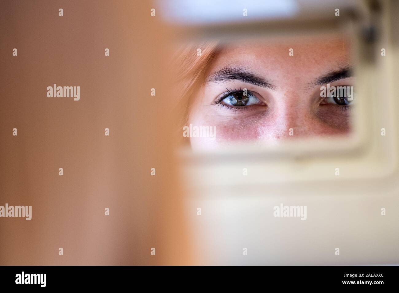 Young woman driver checking rear view mirror looking backwards while ...