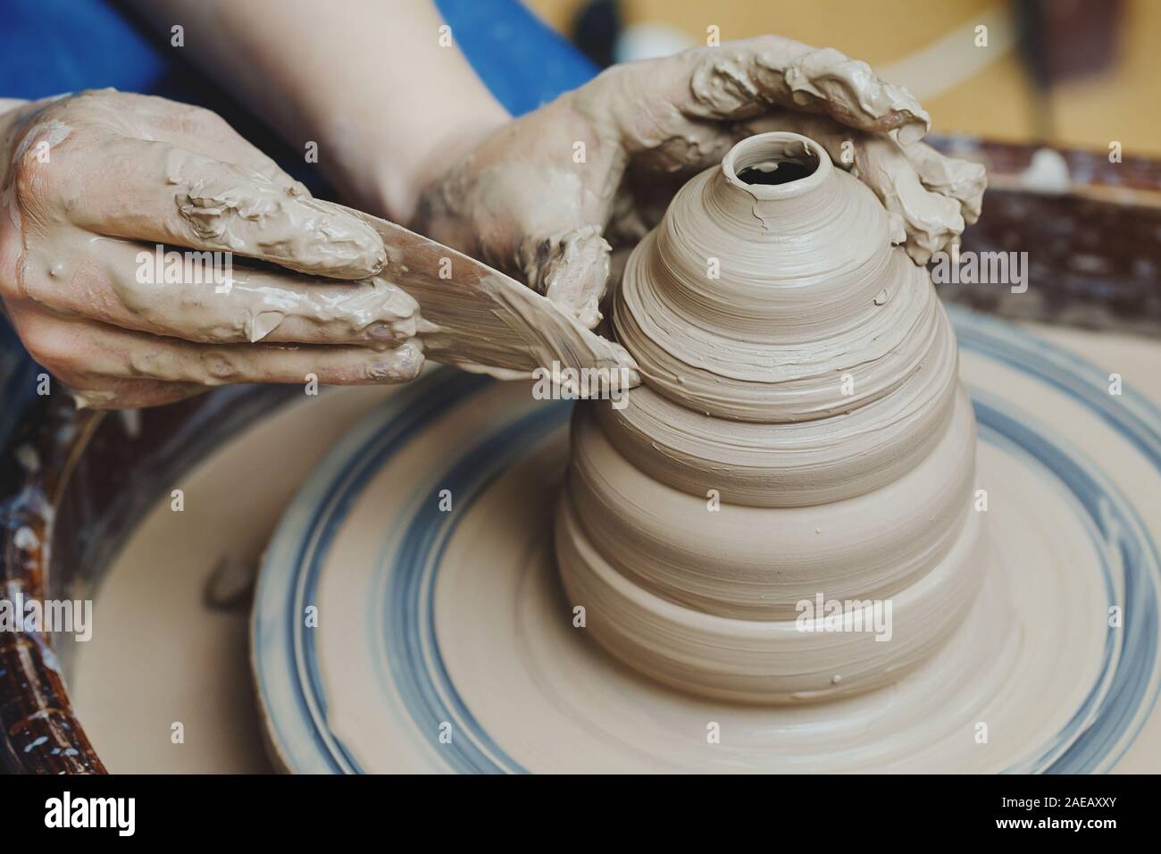 Woman hands on pottery wheel, potter at work. Craftsman artist shapes ...