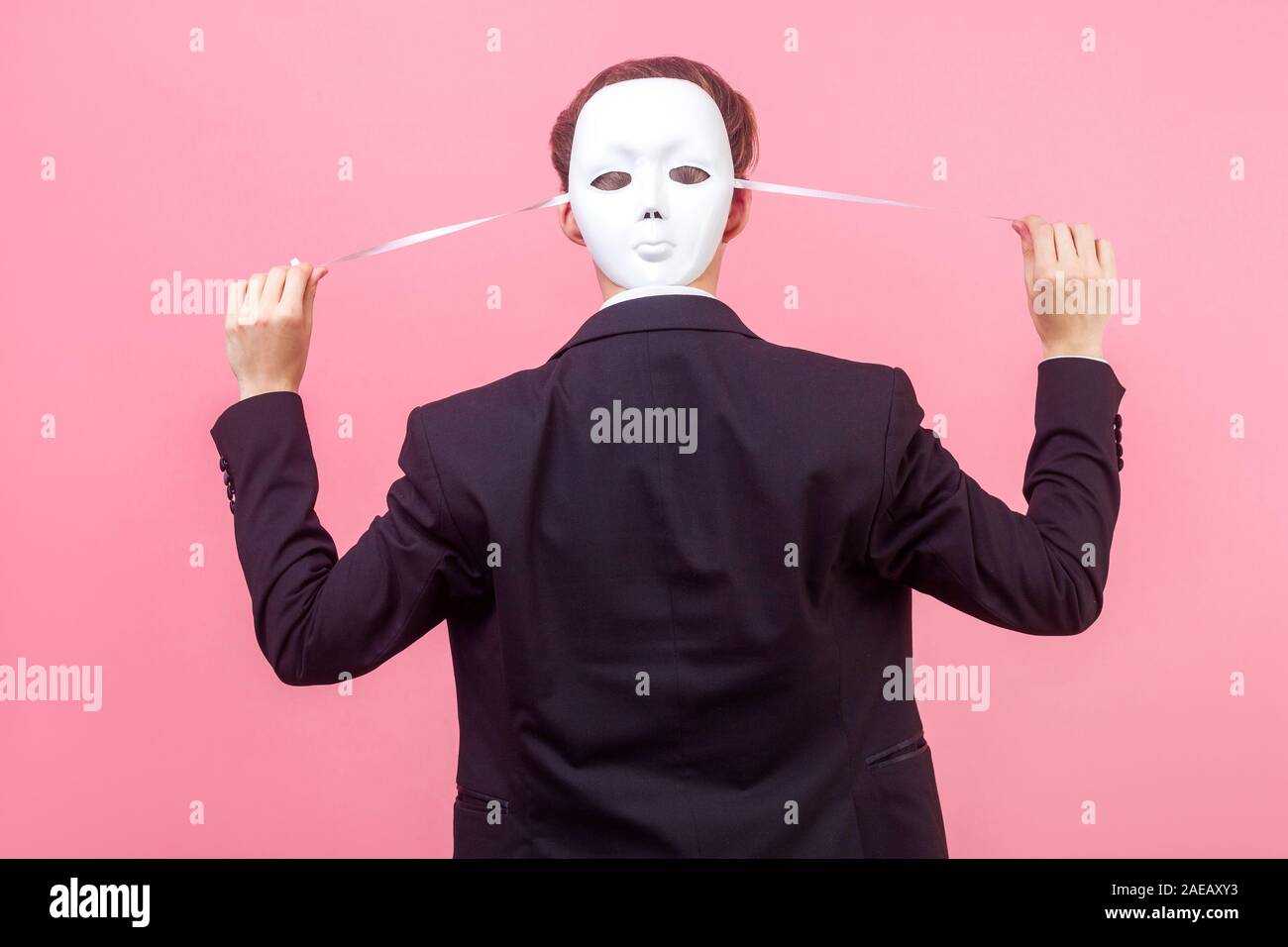 Businessman in black suit standing with his back turned to camera and ...