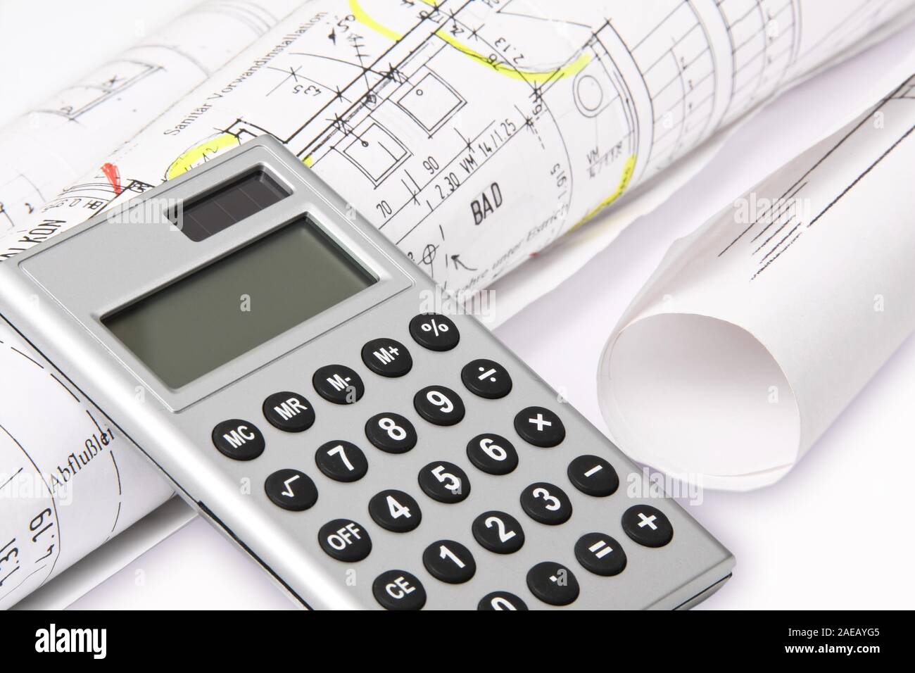 Bundled blueprints with calculator Stock Photo - Alamy