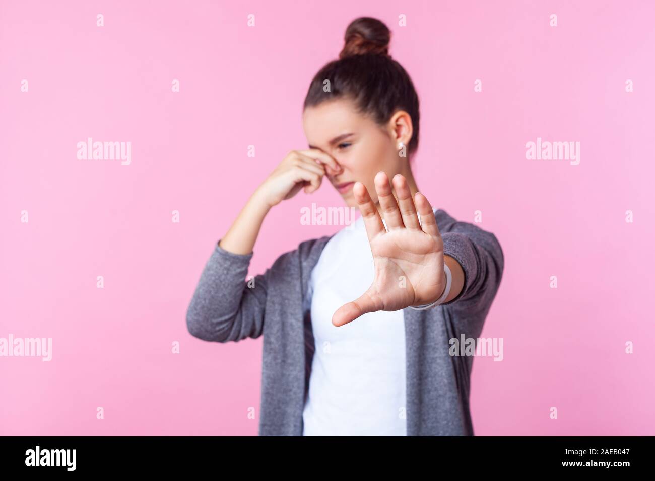 Portrait of confused disgusted teen girl with bun hairstyle in casual ...