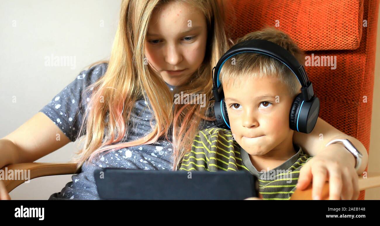 Childern uses modern technology. Boy with girl surf the internet and ...