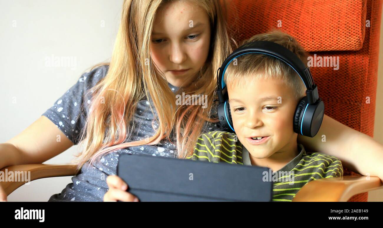 Childern uses modern technology. Boy with girl surf the internet and ...