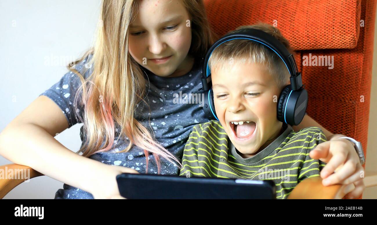 Childern uses modern technology. Boy with girl surf the internet and play online games Stock ...