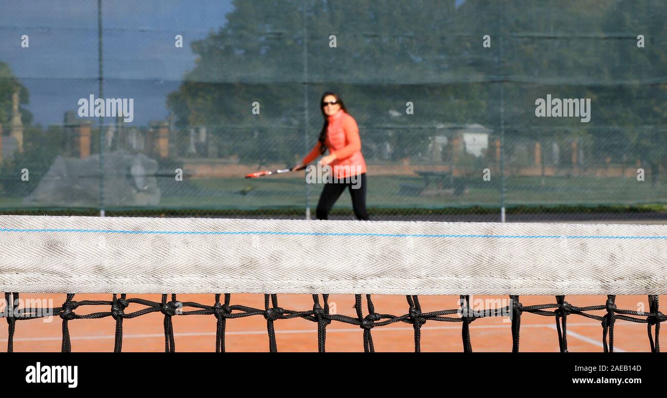 Young woman playing tennis. Girl is practicing tennis. Focus on the net ...