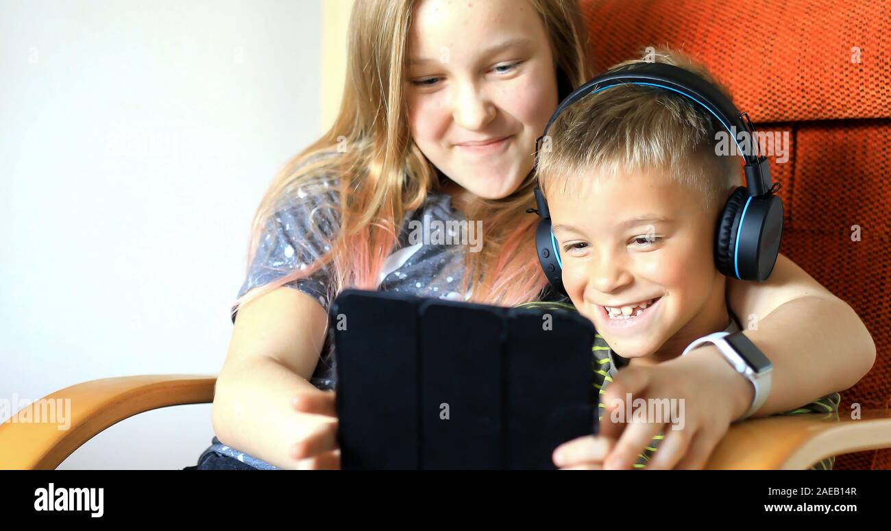 Childern uses modern technology. Boy with girl surf the internet and play online games Stock ...