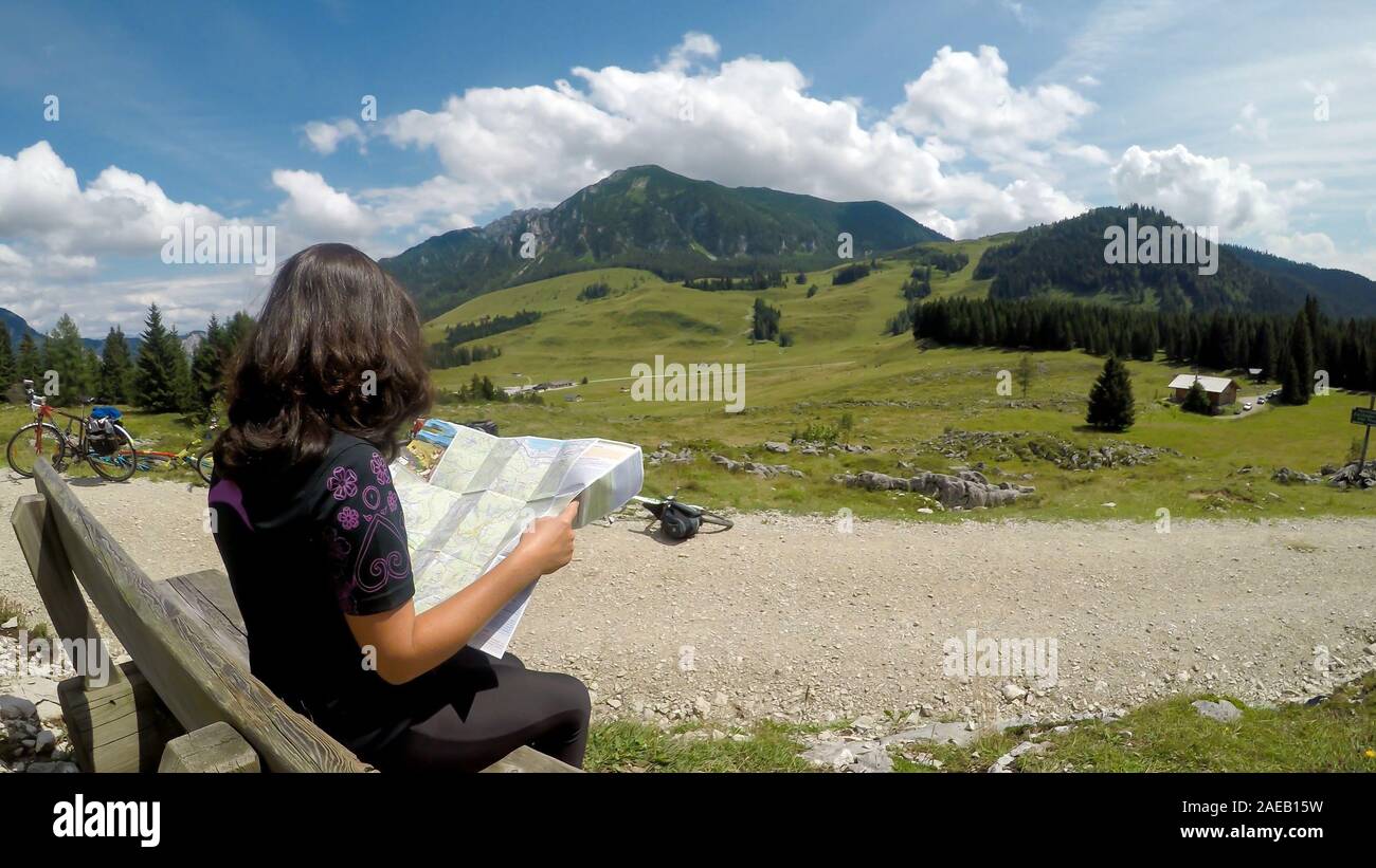 Summer time in the Austrian alps. Young woman on a cycling trip ...