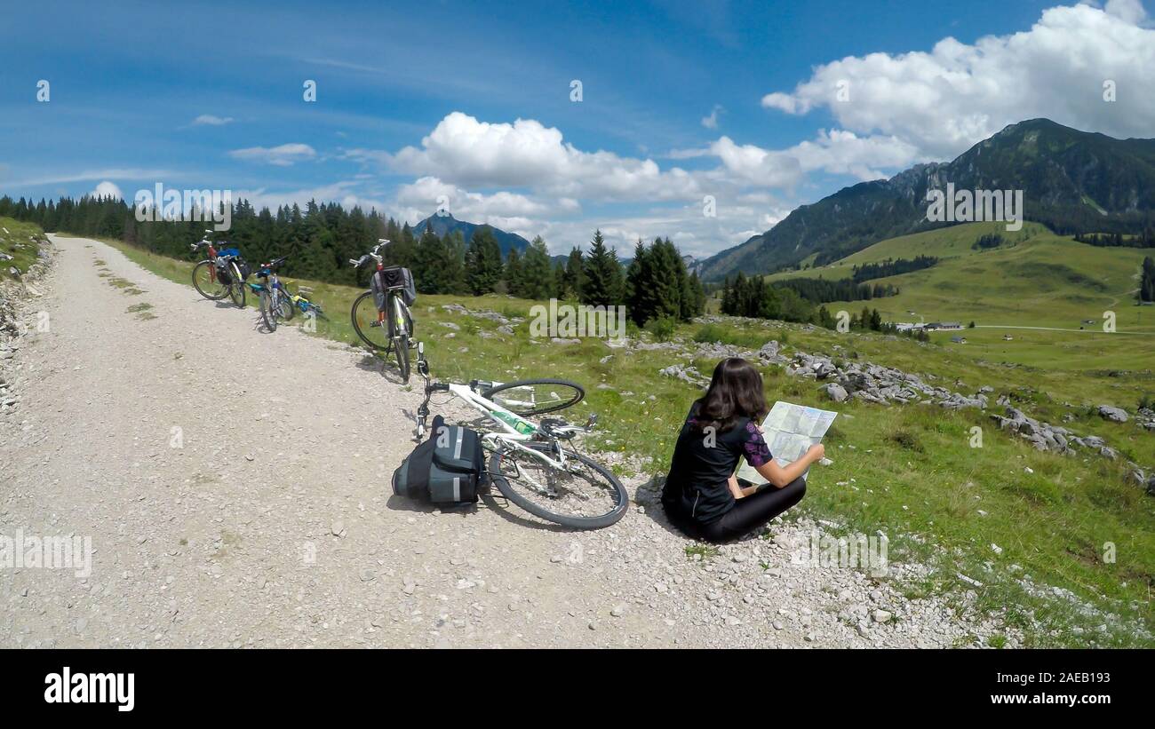 Summer time in the Austrian alps. Young woman on a cycling trip ...
