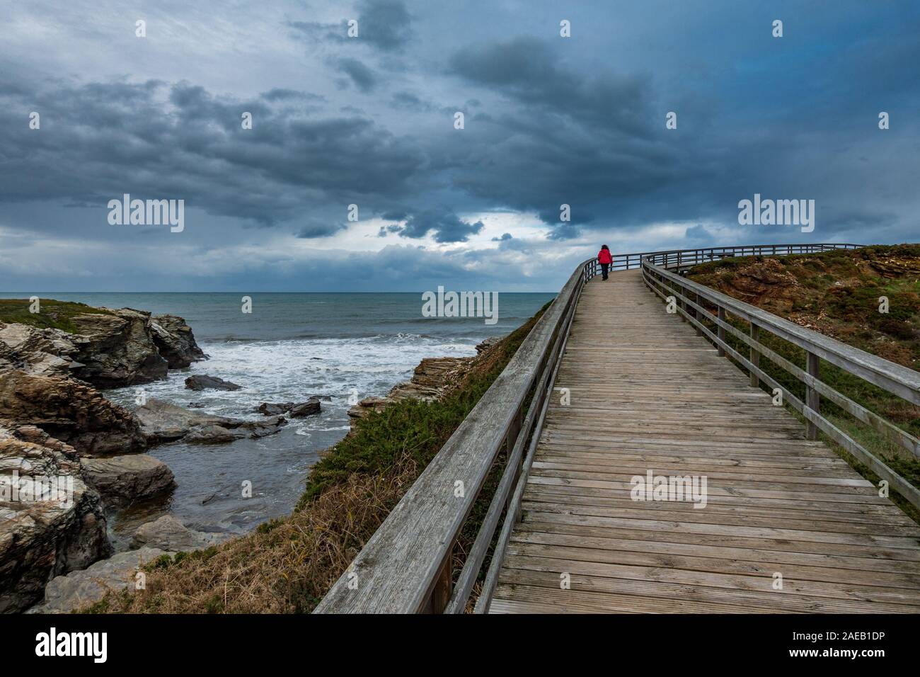 Wooden track through the ocean with hiker Stock Photo - Alamy