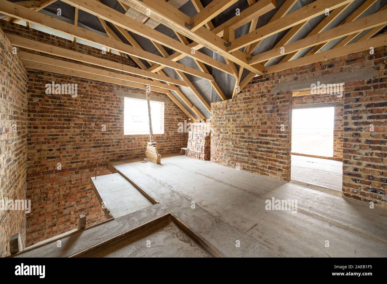 Interior of unfinished brick house with concrete floor, bare walls ...