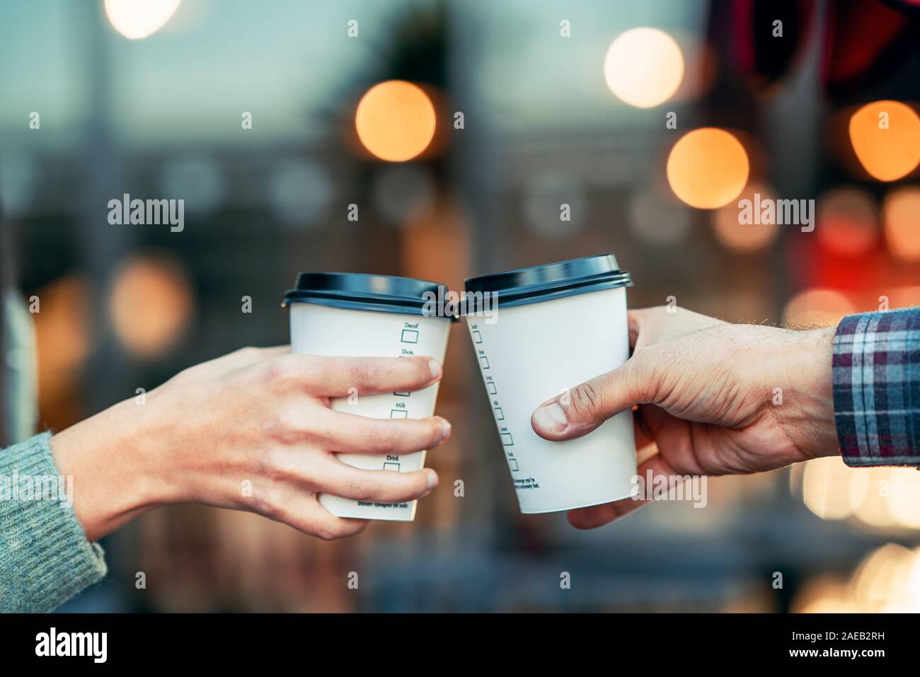 a couple is toasting with paper cup and drink coffee Stock Photo - Alamy