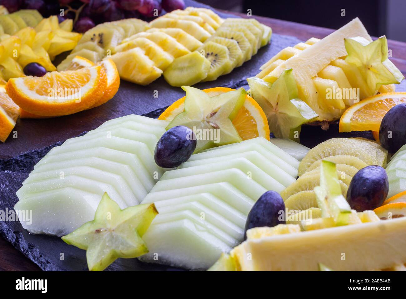 Sliced fruits on a plate - Pineapple - Orange - Grape - Kiwi- Starfruit ...