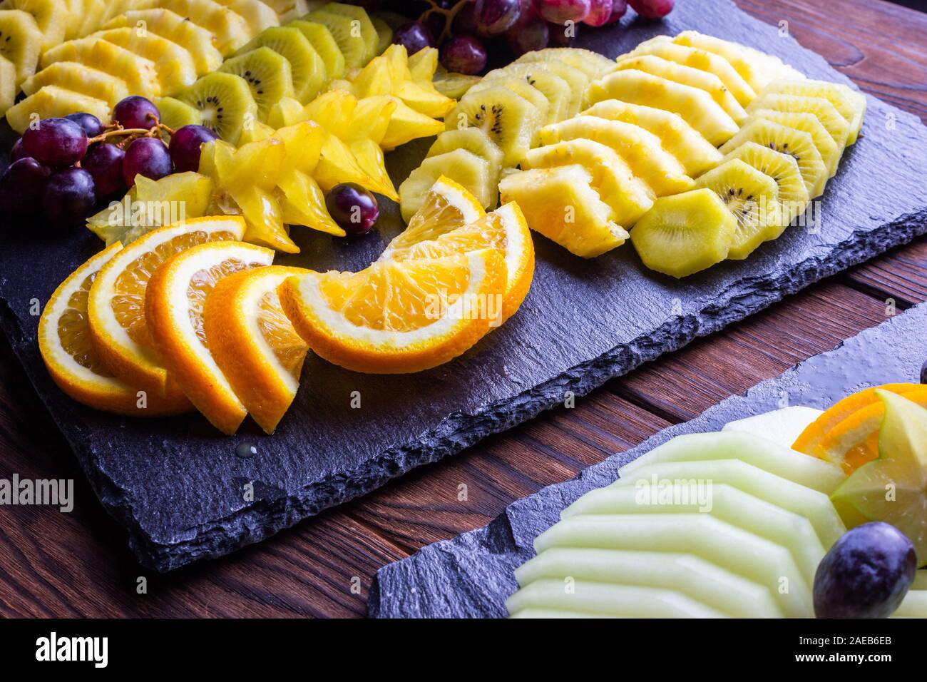 Sliced fruits on a plate - Pineapple - Orange - Grape - Kiwi- Starfruit ...