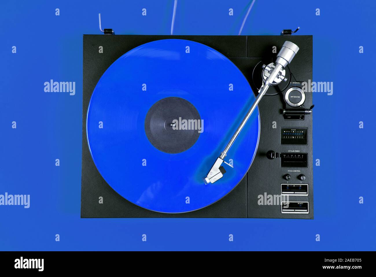 Colored vinyl record on a red background with copy space. Top view ...