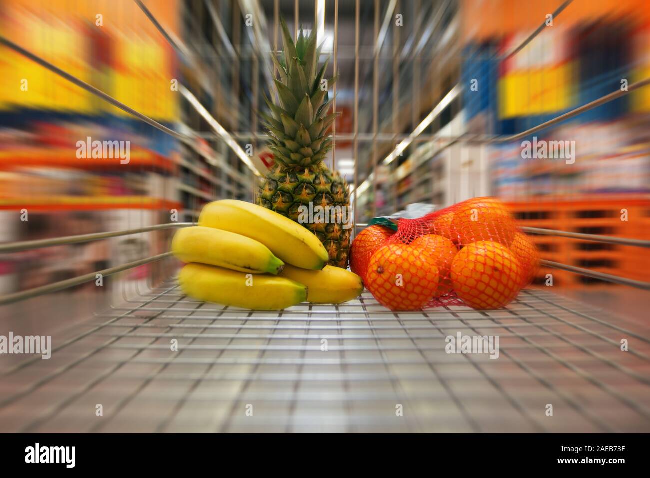 Shopping cart with fruits moving through supermarket Stock Photo - Alamy