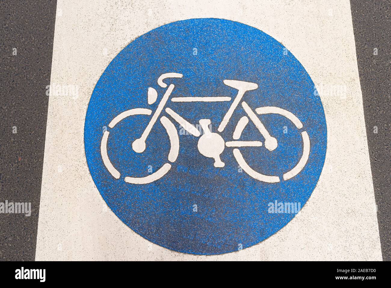 A round road sign depicting a white bicycle on a blue background ...
