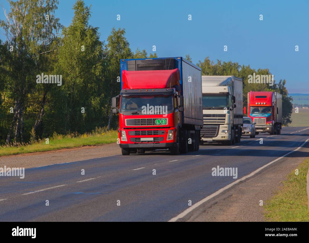 escort of trucks moves on the country highway Stock Photo - Alamy