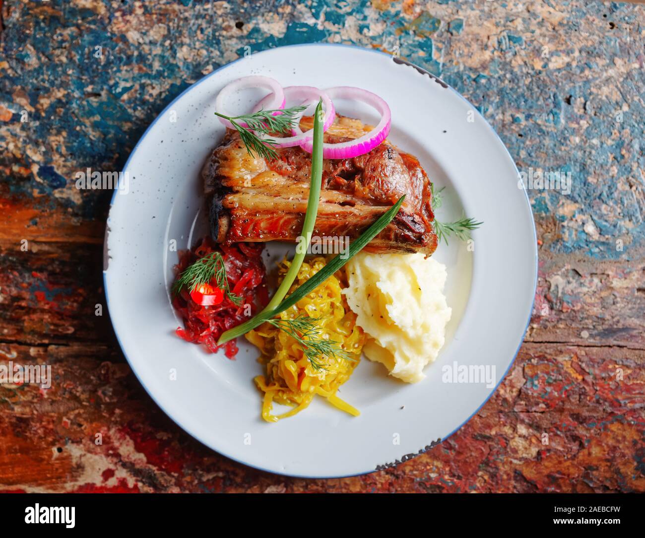 Grilled pork ribs with sauerkraut and mash potatoes on grunge peeled ...