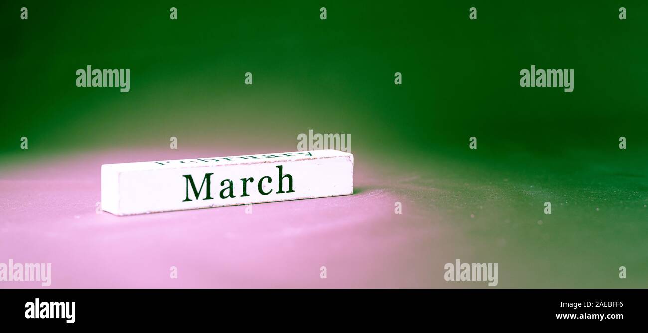 March, name of the month written on vintage white wooden block on green ...