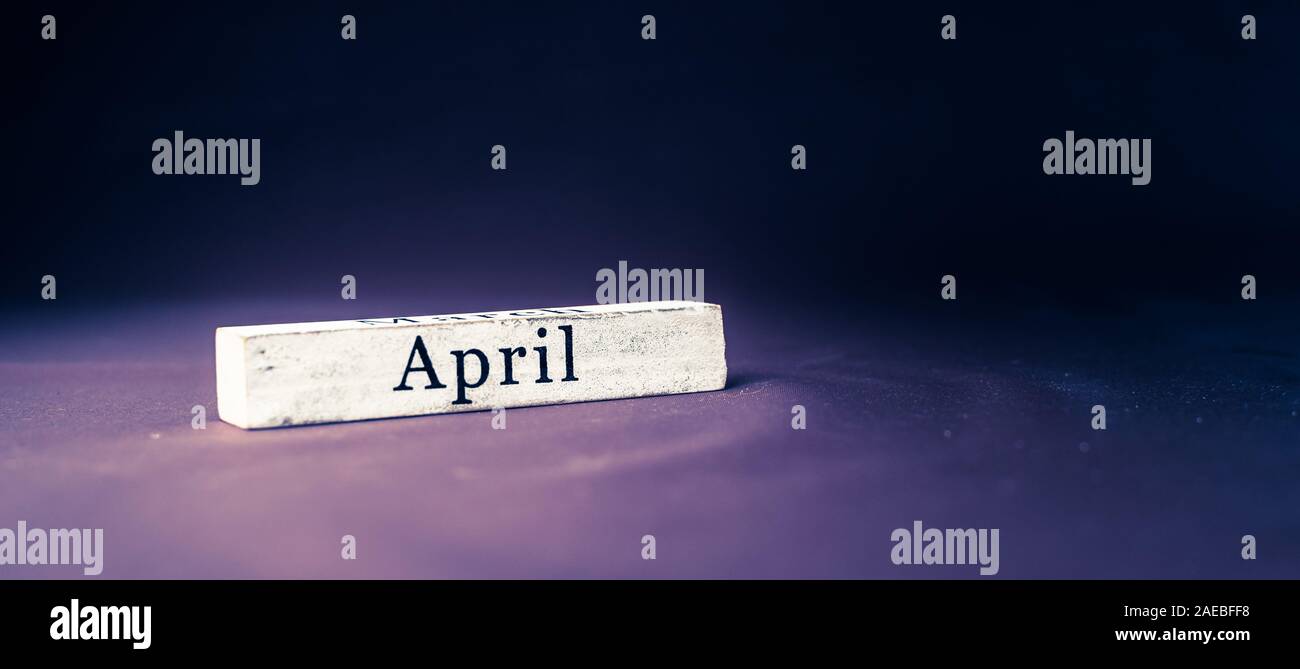April, name of the month written on vintage white wooden block on ...