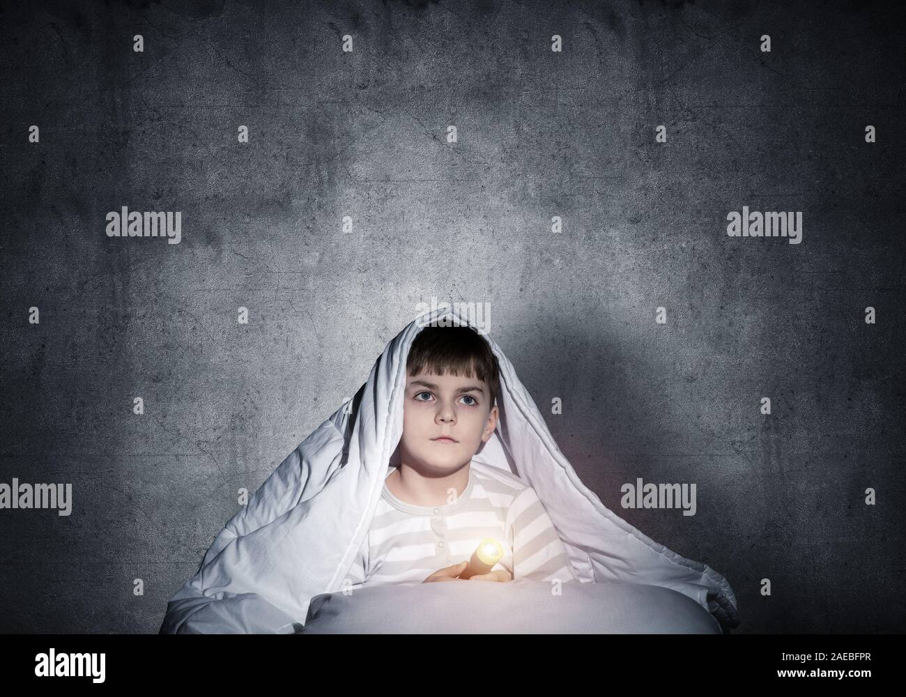 Little child with flashlight hiding under blanket Stock Photo - Alamy
