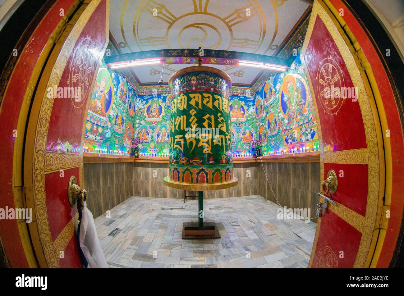 Beautiful huge bhuddhist prayer wheel in an ornately decorated room ...