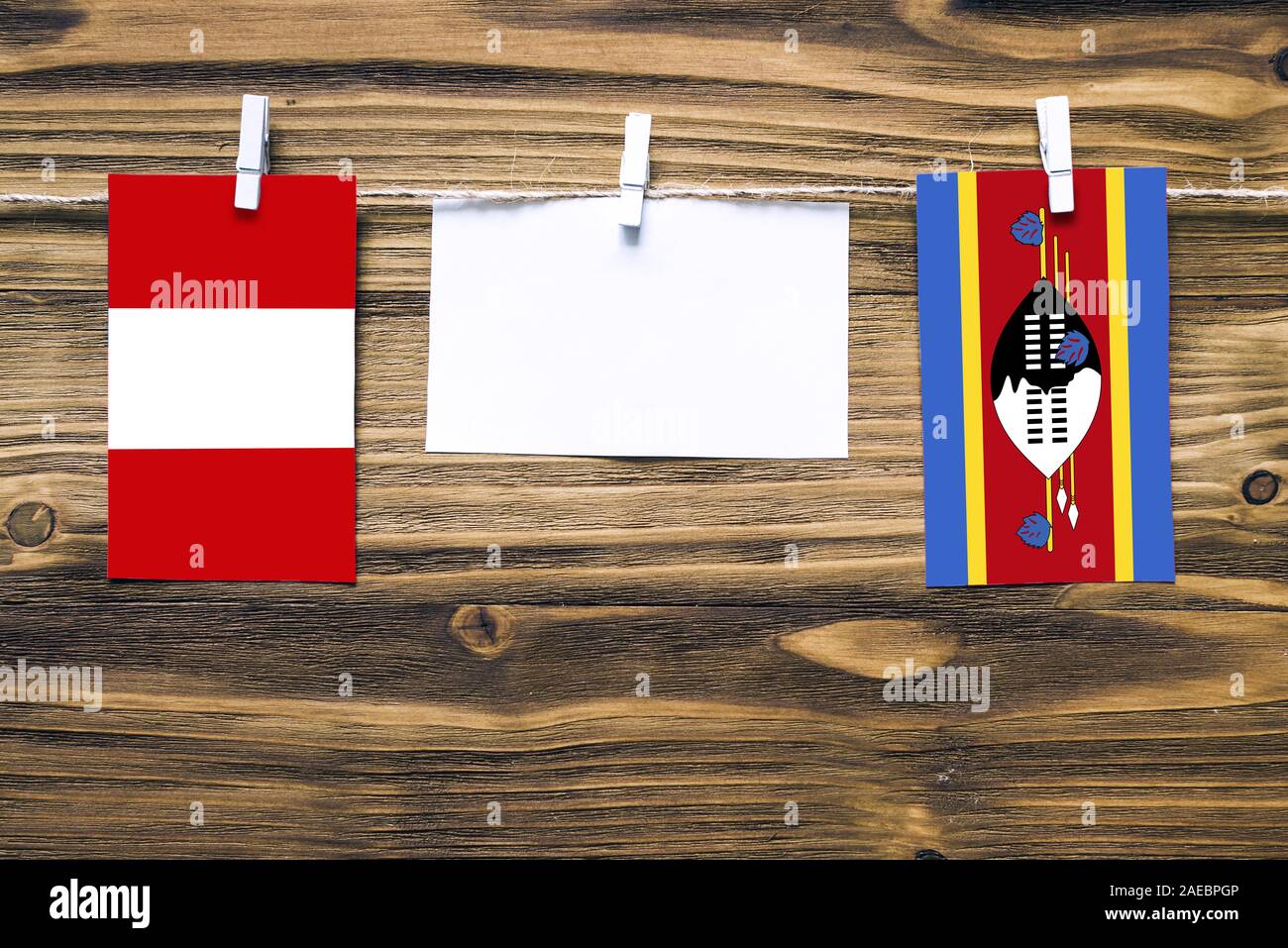 Hanging flags of Peru and Swaziland attached to rope with clothes pins ...