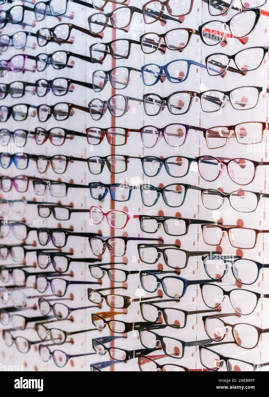 A large assortment of different glasses on a shelf in an optics store ...