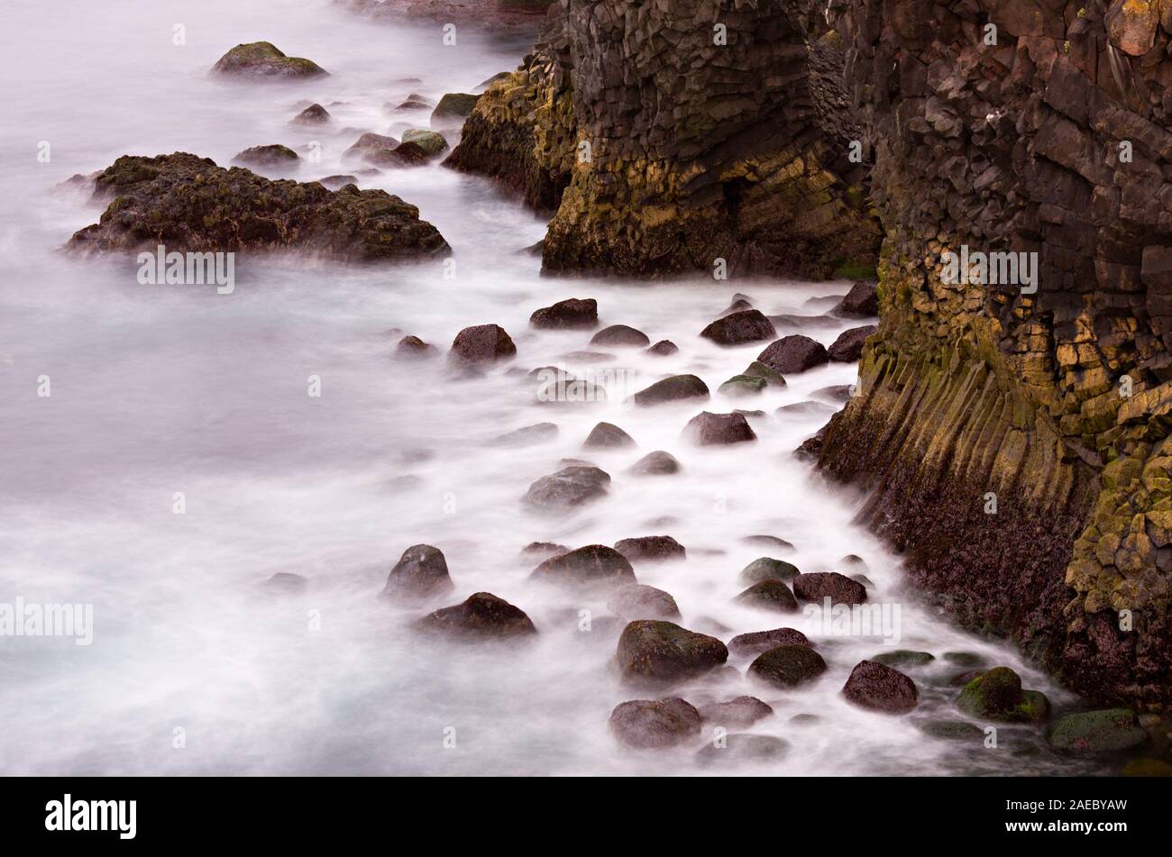 Long exposure shot of basalt columns and boulders in the surf, Iceland ...