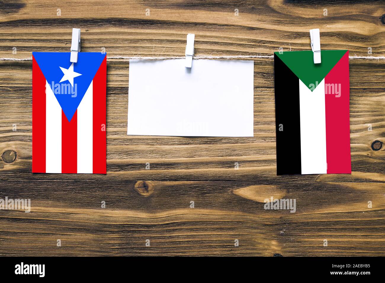 Hanging flags of Puerto Rico and Sudan attached to rope with clothes ...