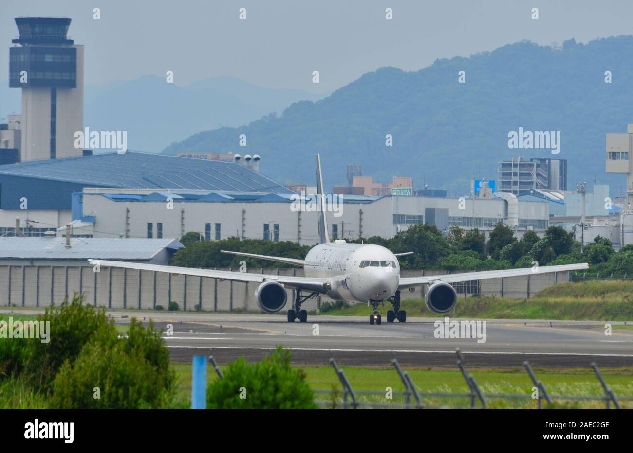 Osaka, Japan - Jun 26, 2019. Airplane taxiing on runway of Osaka Itami ...