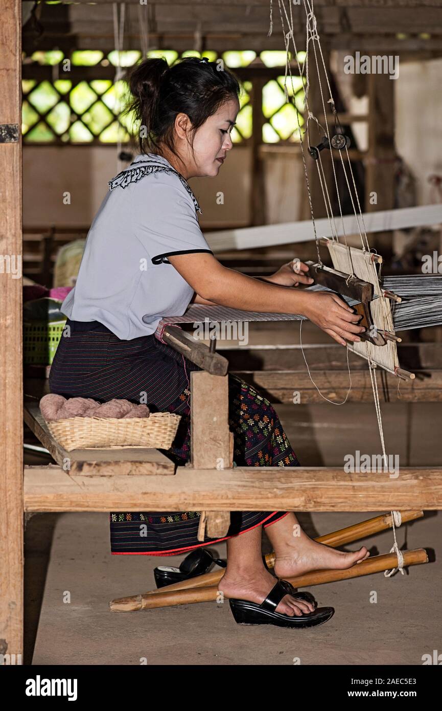 Young woamn weaving on a traditional Lao-Thai style loom, Ban Phanom ...