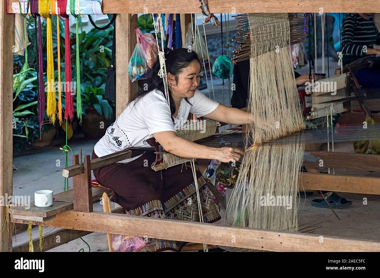 Lao woamn weaving on a traditional Lao-Thai style loom, Ban Phanom ...
