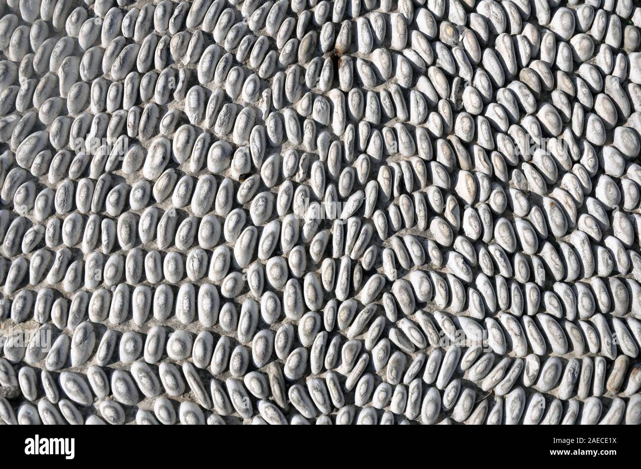 The sidewalk or wall of small pebbles lined with a pattern. Art ...
