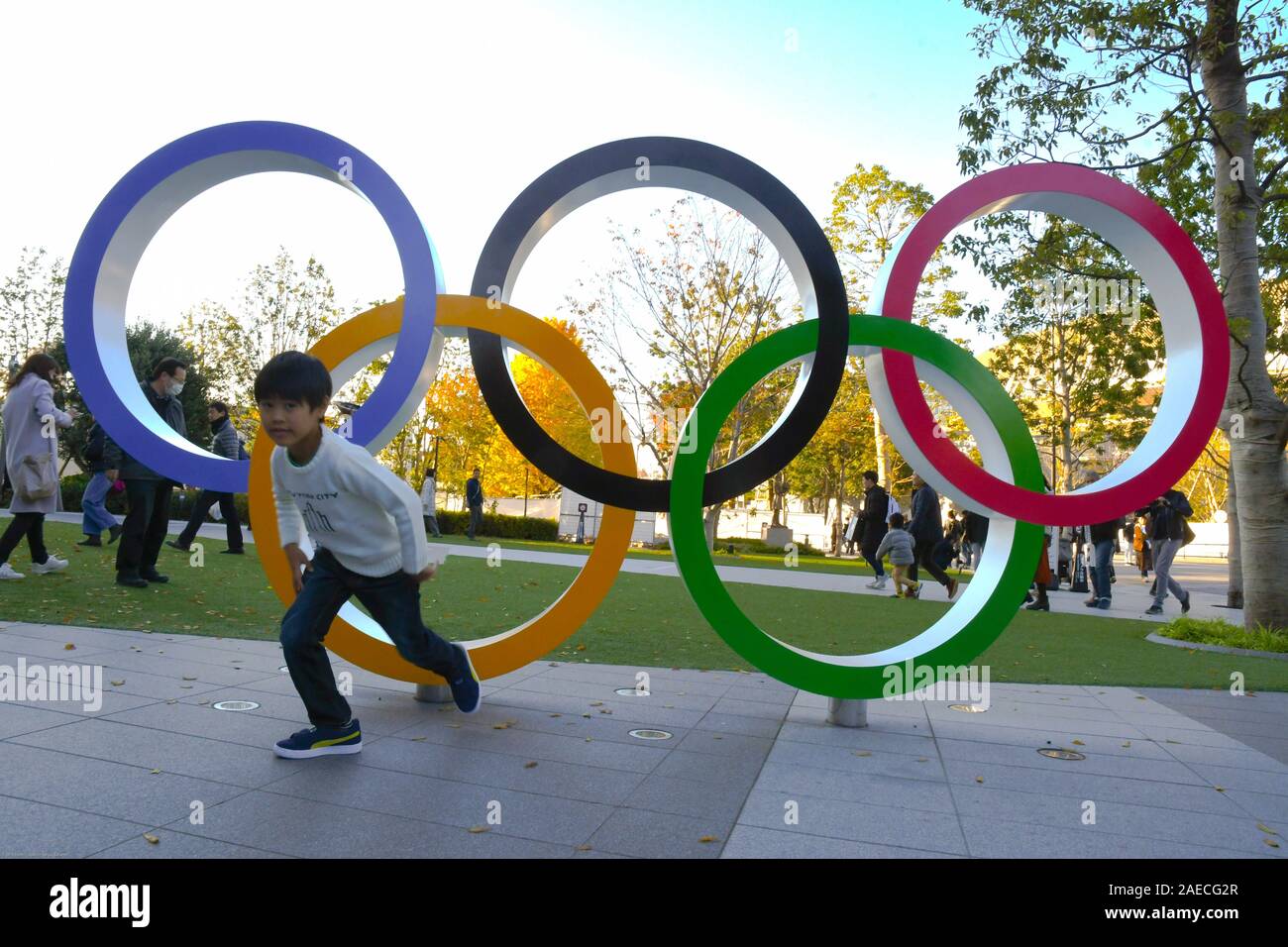 Tokyo, Japan. 8th Dec, 2019. A boy runs near the iconic olympic symbol ...