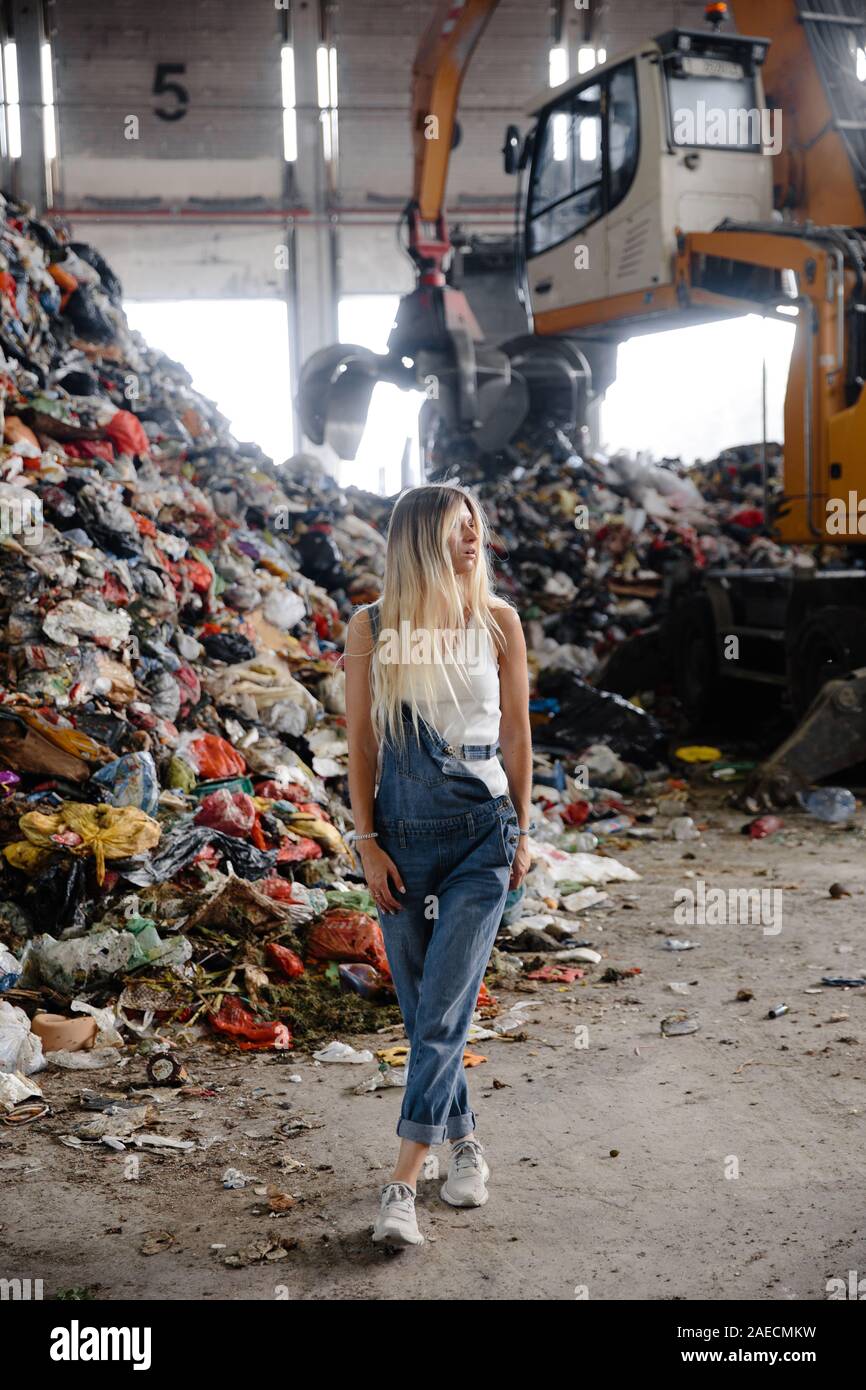 Nature pollution activist at a huge trash dump - Young blonde woman ...