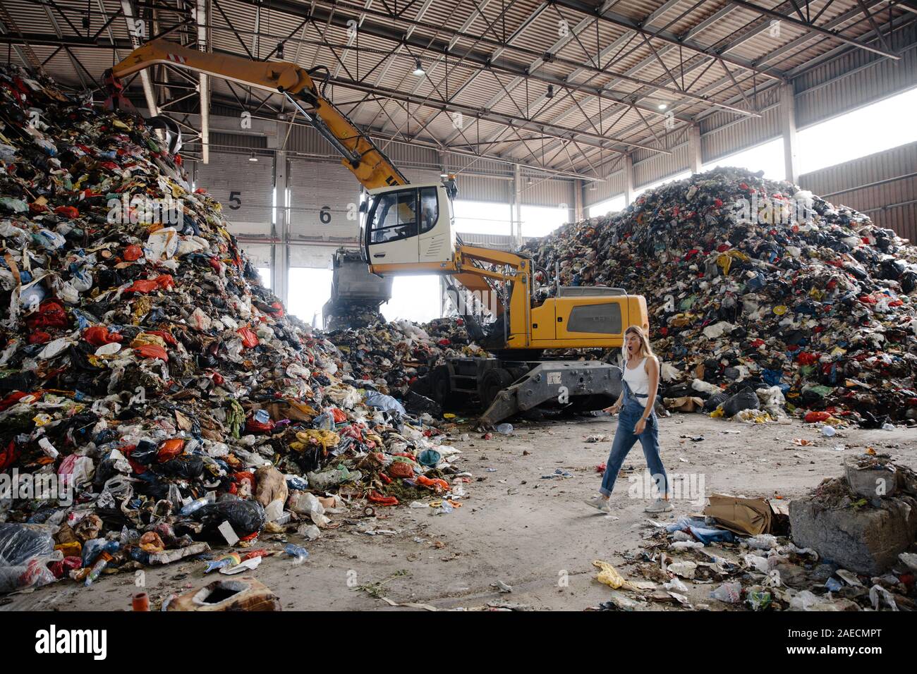 Nature pollution activist at a huge trash dump - Young blonde woman ...